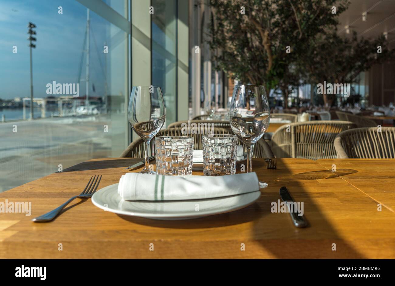 Table prepared on a restaurant sunny covered outdoor terrace with ...