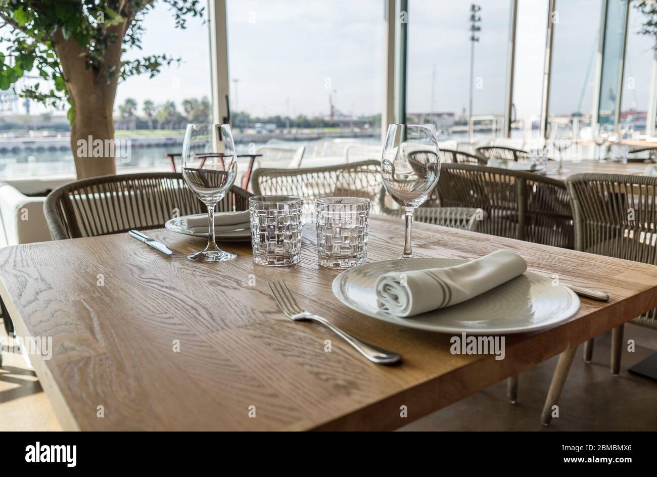 Table prepared on a restaurant sunny covered outdoor terrace with ...