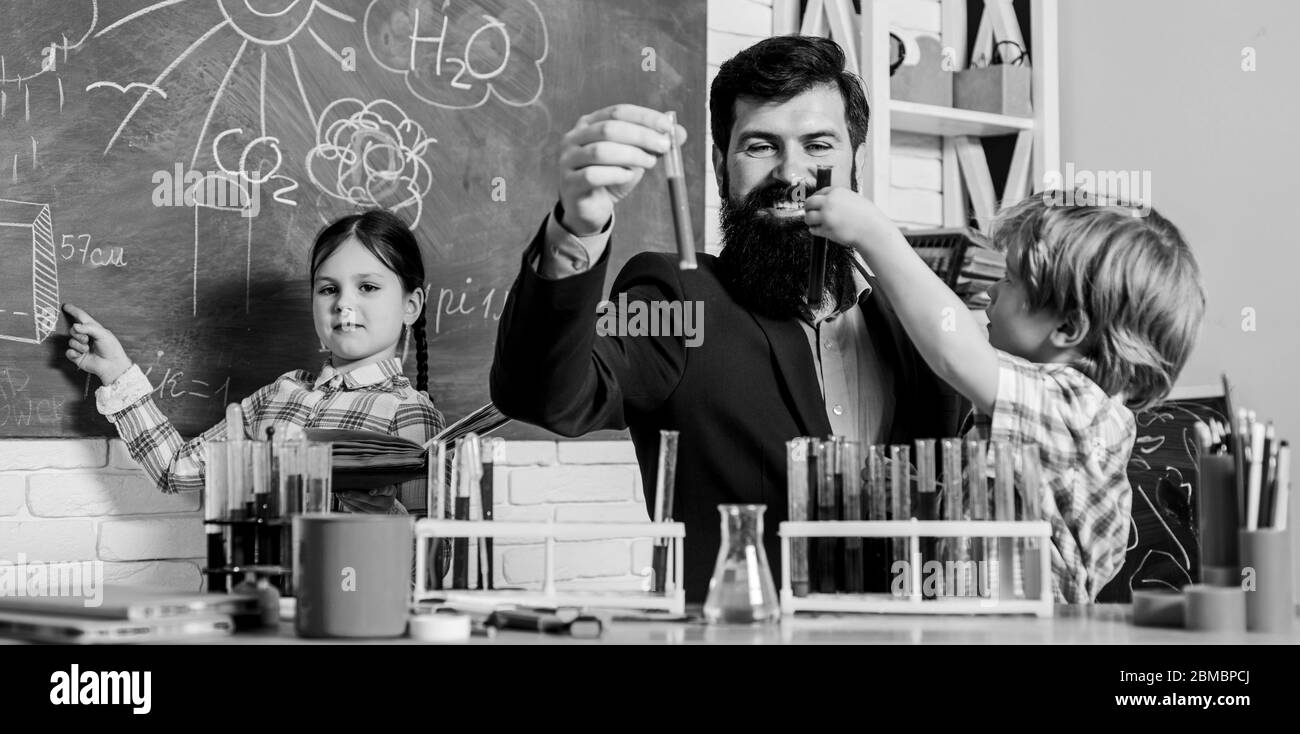 Chemistry experiment. Teacher and pupils test tubes in classroom ...
