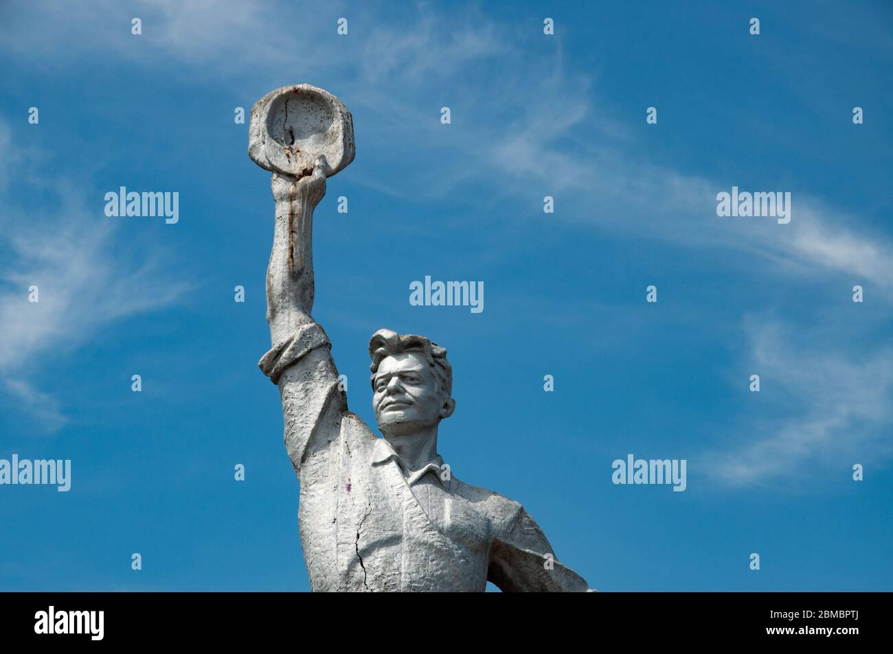 Closeup of old dilapidated stone statue of Soviet brave worker. Social ...