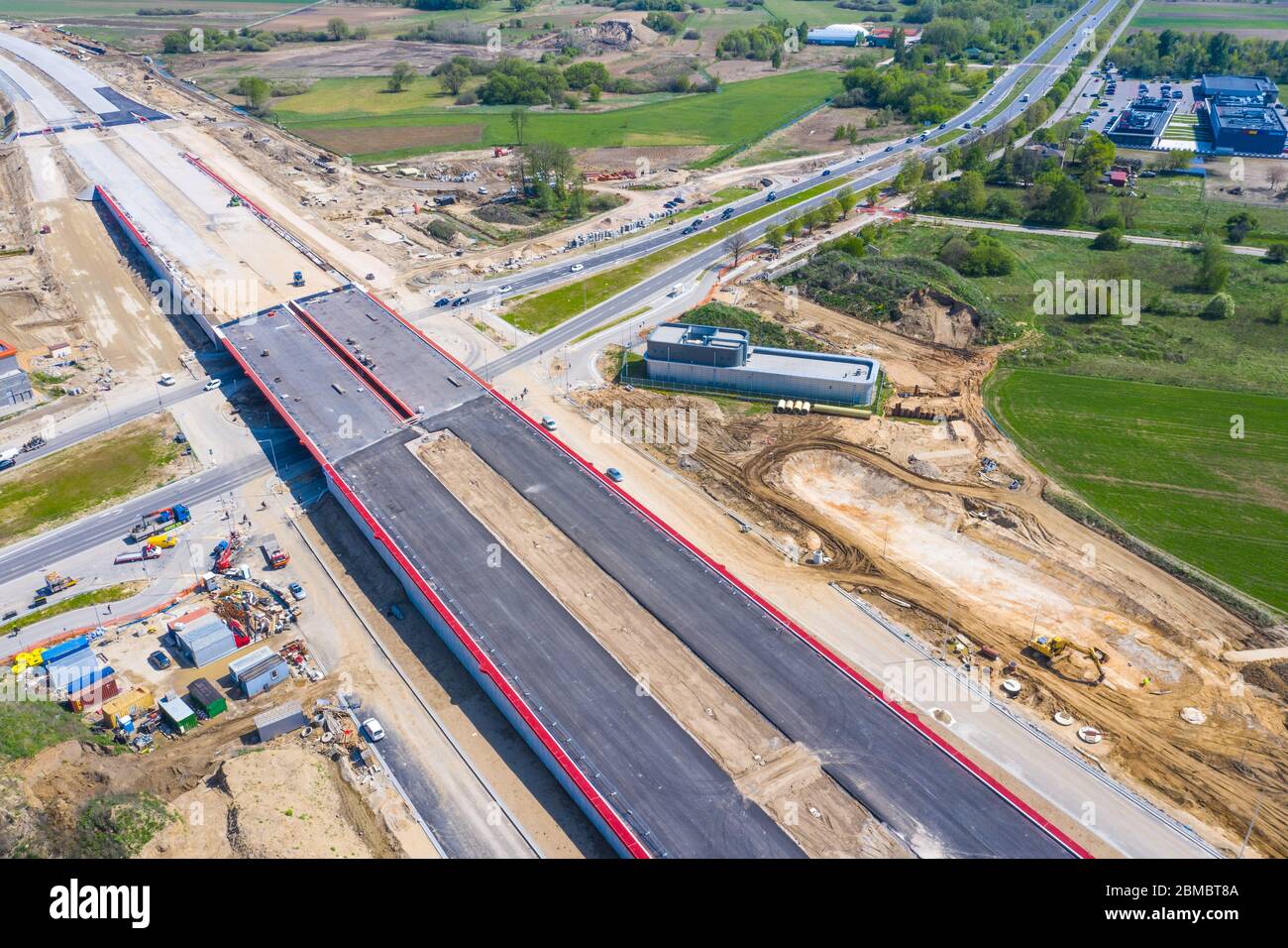 Aerial panorama top down view of an unfinished asphalt covered road ...