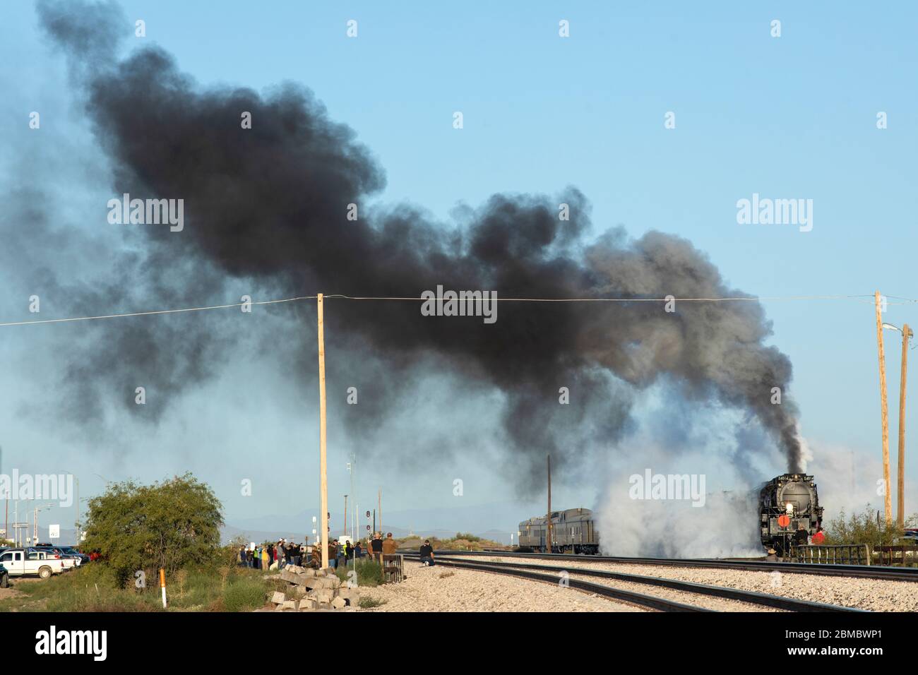 Steam engine smoking a lot moving on tracks under blue sky Stock Photo ...