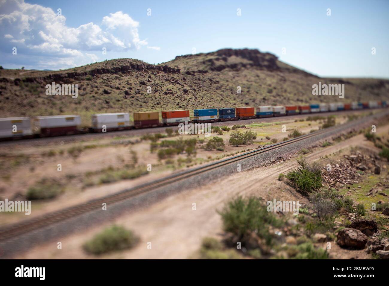 Select focus freight train containers passing through desert canyon ...