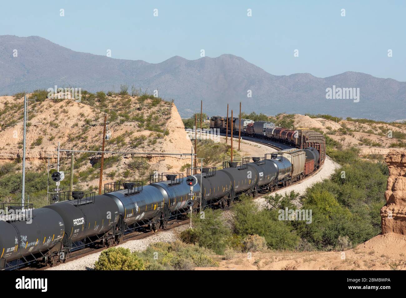 A mixed freight train takes a curve through a desert landscape Stock ...