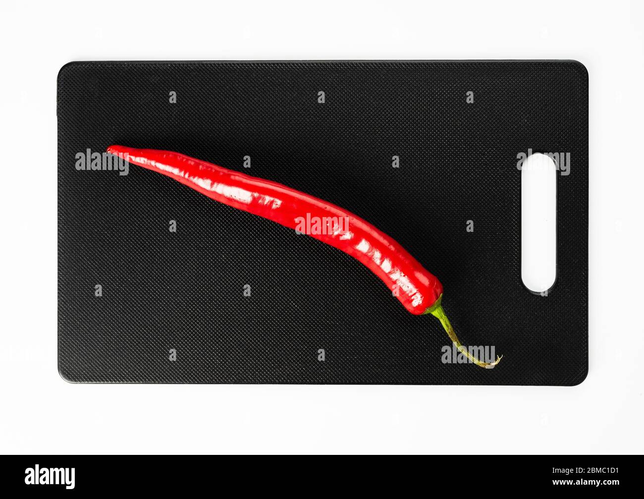 Red hot pepper on a black cutting board Stock Photo - Alamy