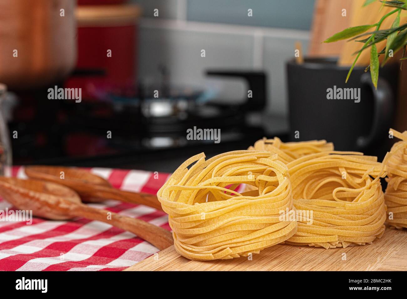 Dry spaghetti on a kitchen counter with cooking utensils Stock Photo ...