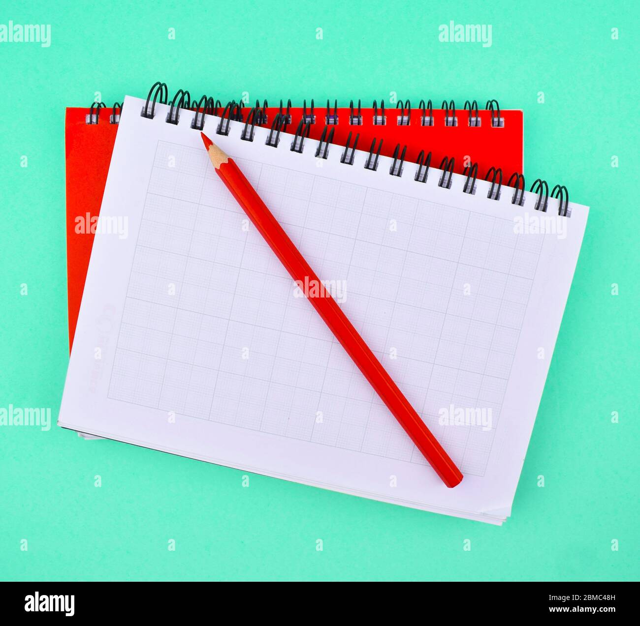 One pencil placed on two different color note paper diary placed on top ...