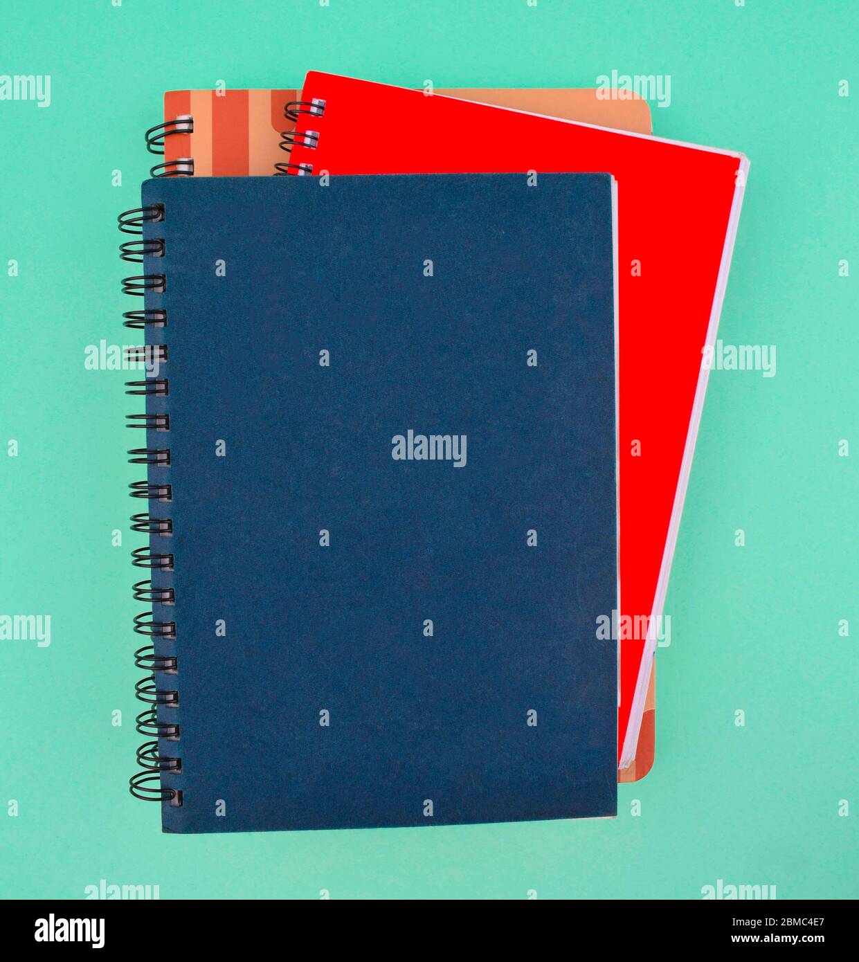 Three different color note paper diary placed on top of each other on a ...