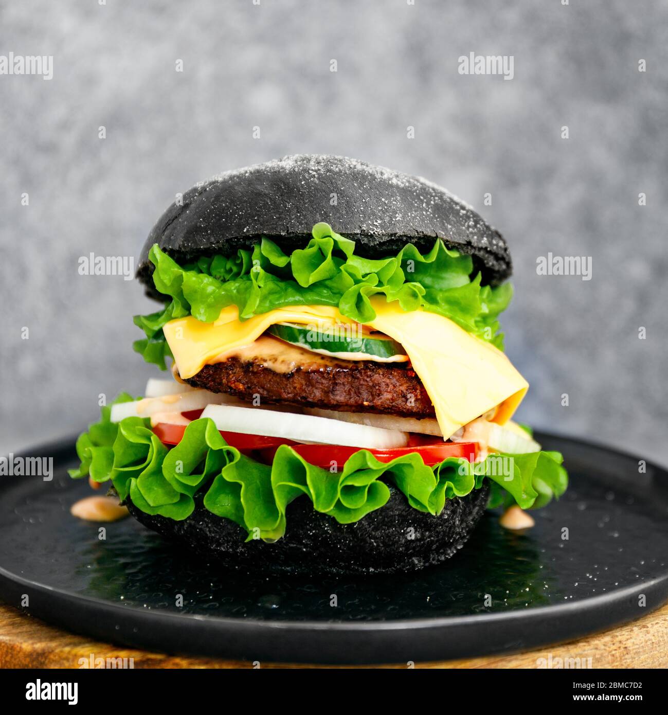 Big black burger with marble beef patty, cheese and fresh vegetables ...