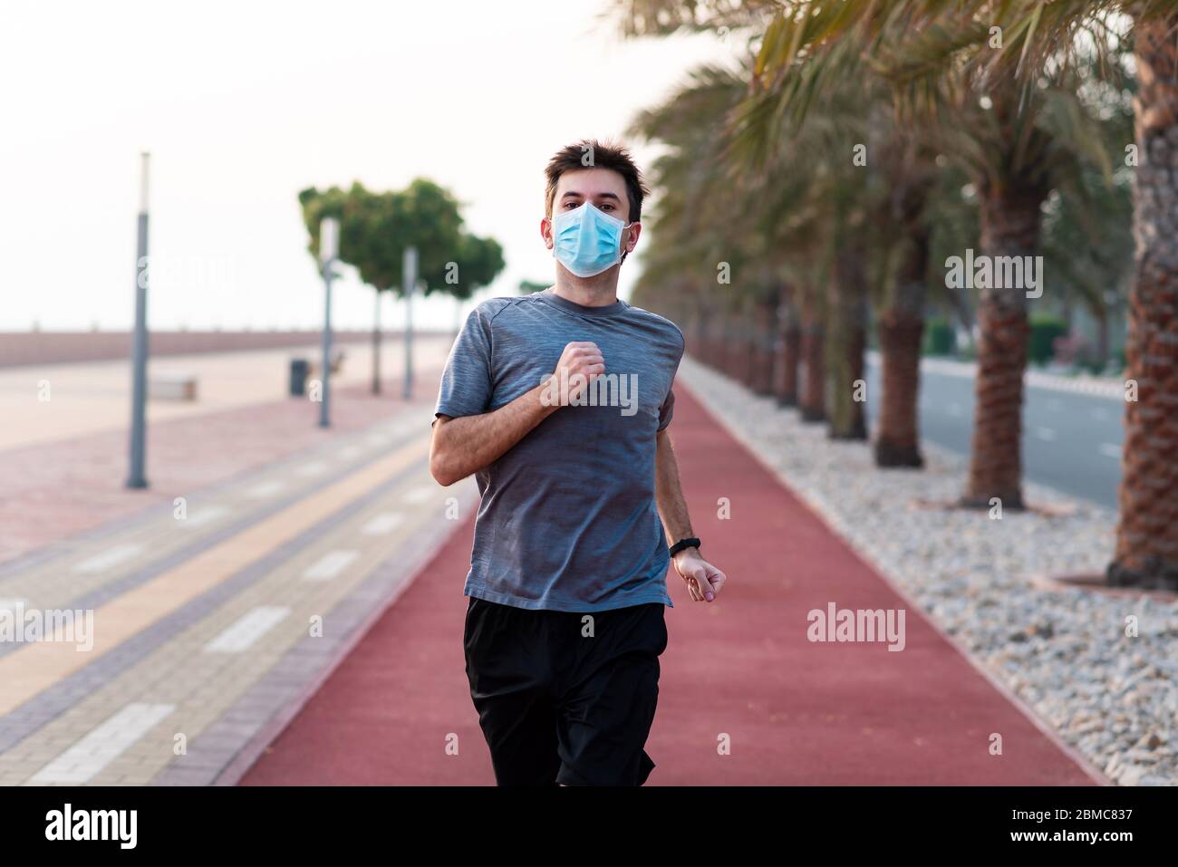 Man jogging on the running track wearing protective surgical mask Stock ...