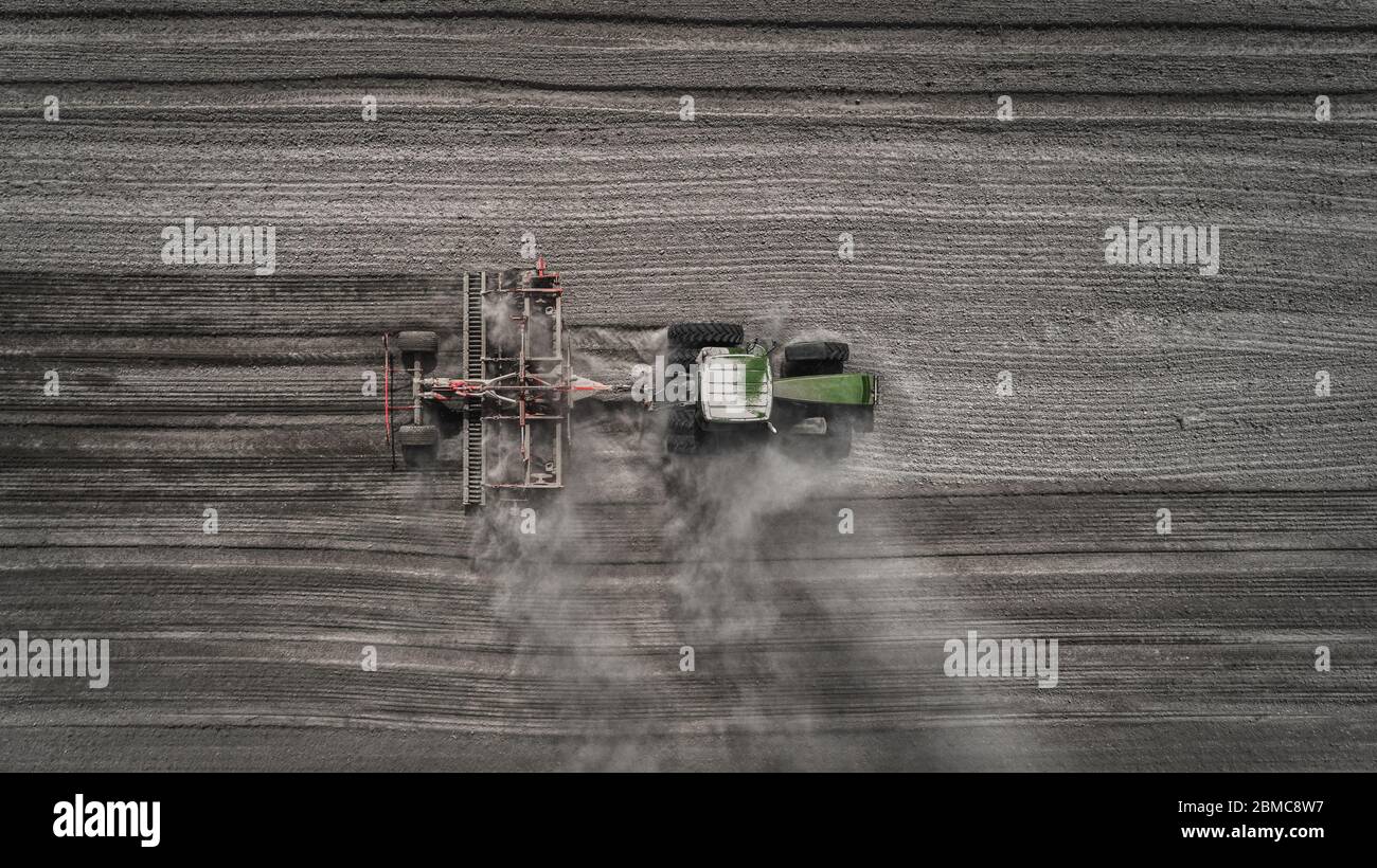 Aerial view of a clean field in which the tractor makes vertical ...