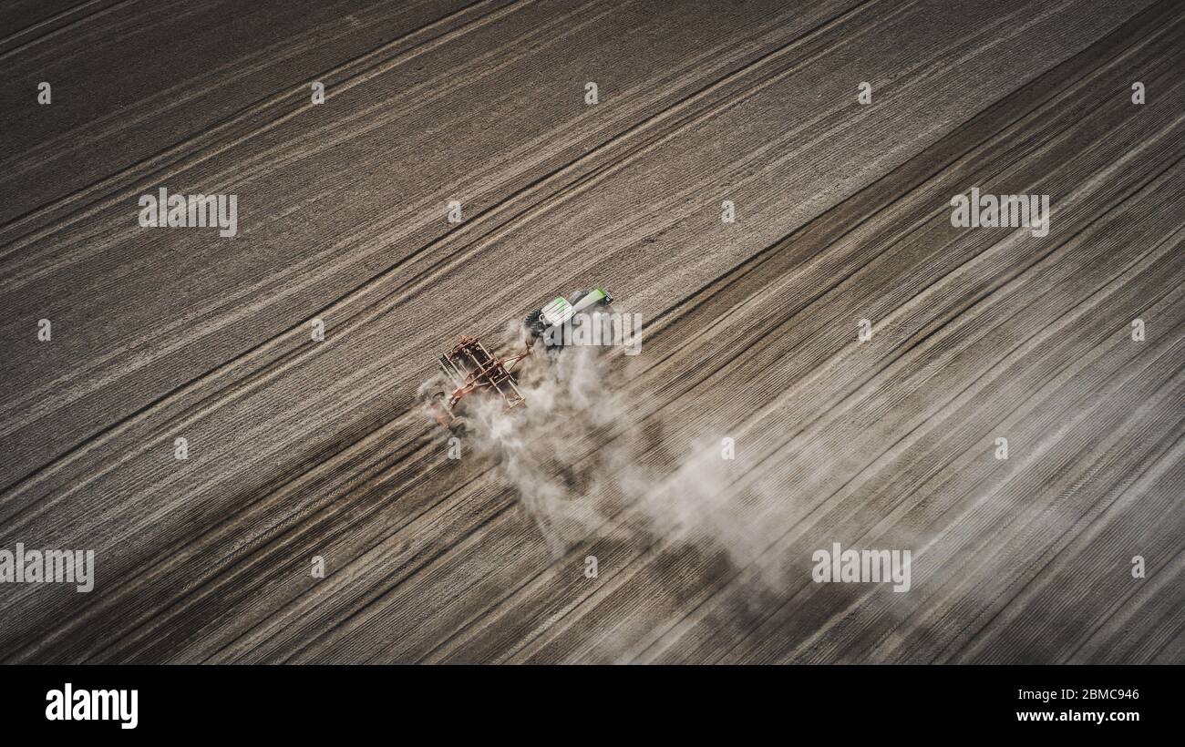 Aerial view of a clean field in which the tractor makes vertical ...