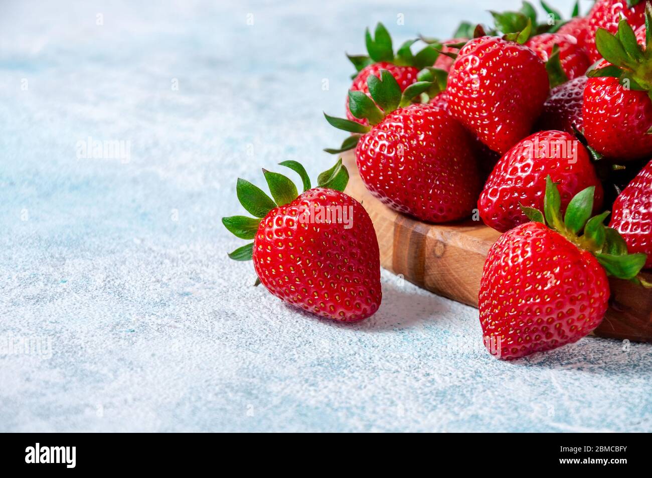 Fresh Strawberries on Wooden Board on Light Blue Background Stock Photo ...