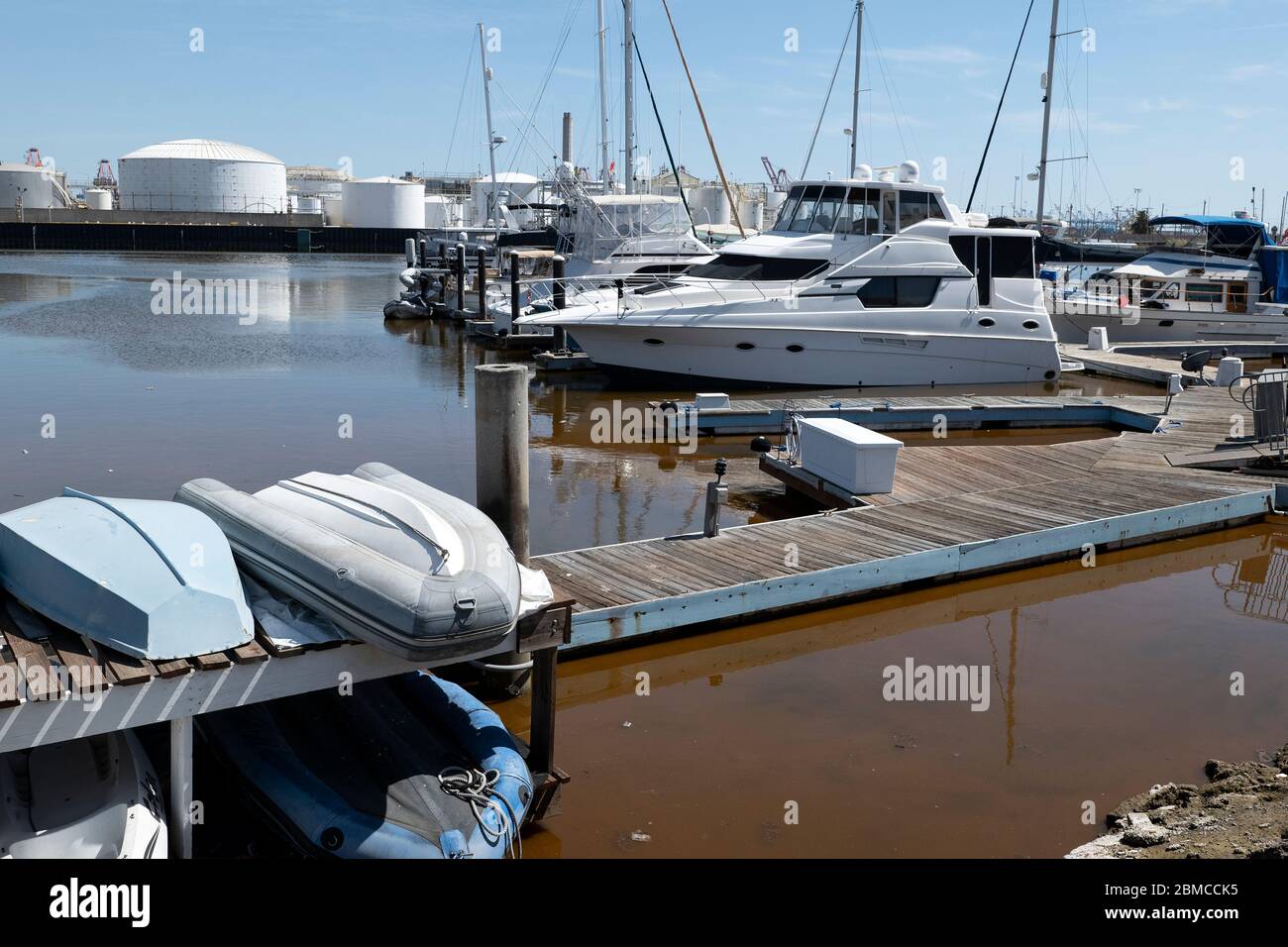 Extremely polluted water in a boat marina near oil storage tanks Stock ...