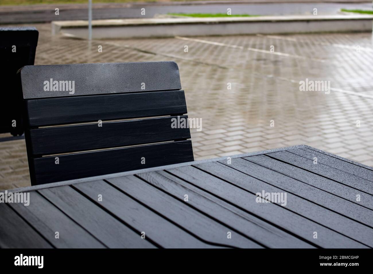 Street table and chair wet in the rain Stock Photo - Alamy