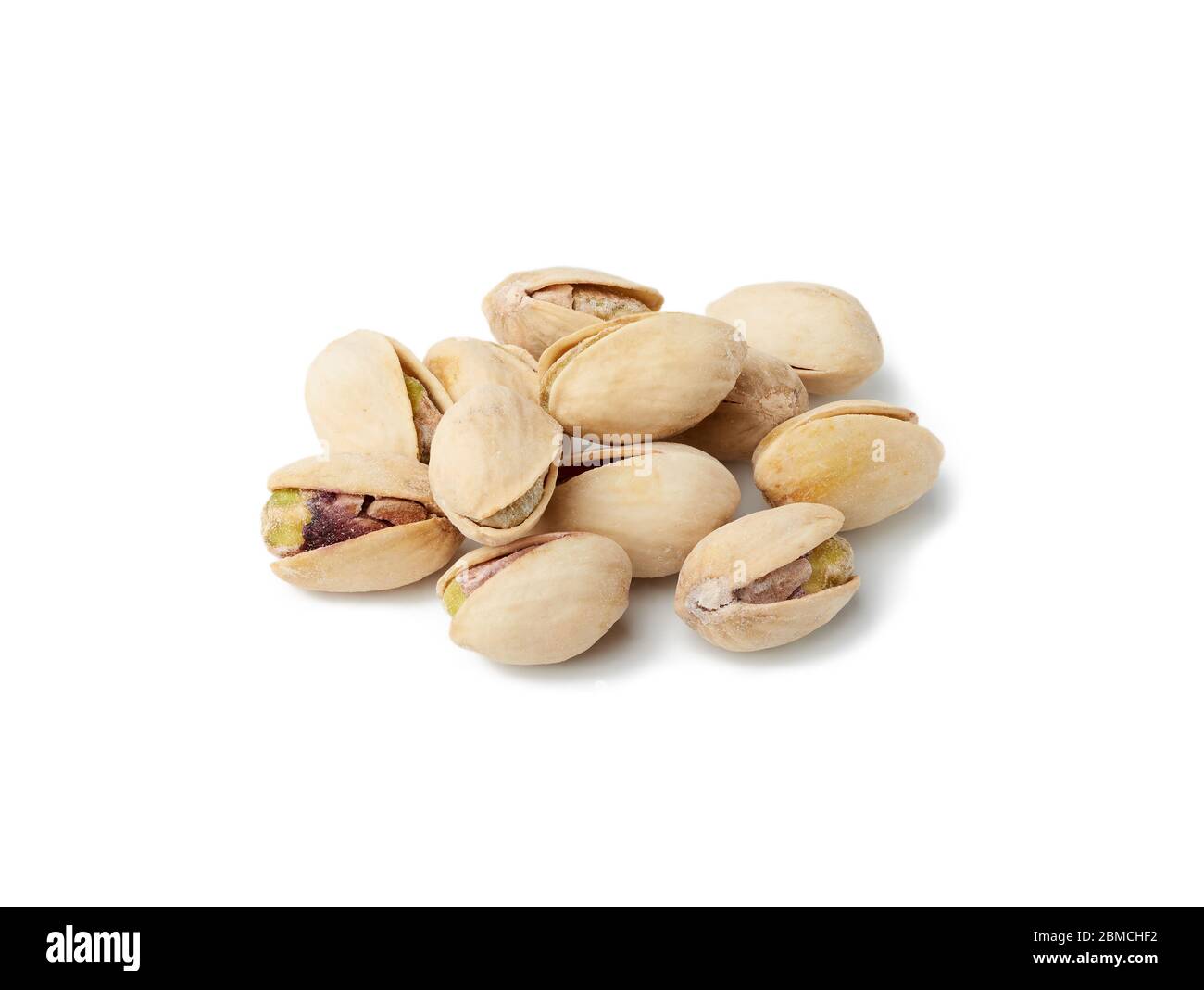 bunch of salted open inshell pistachios isolated on a white background ...