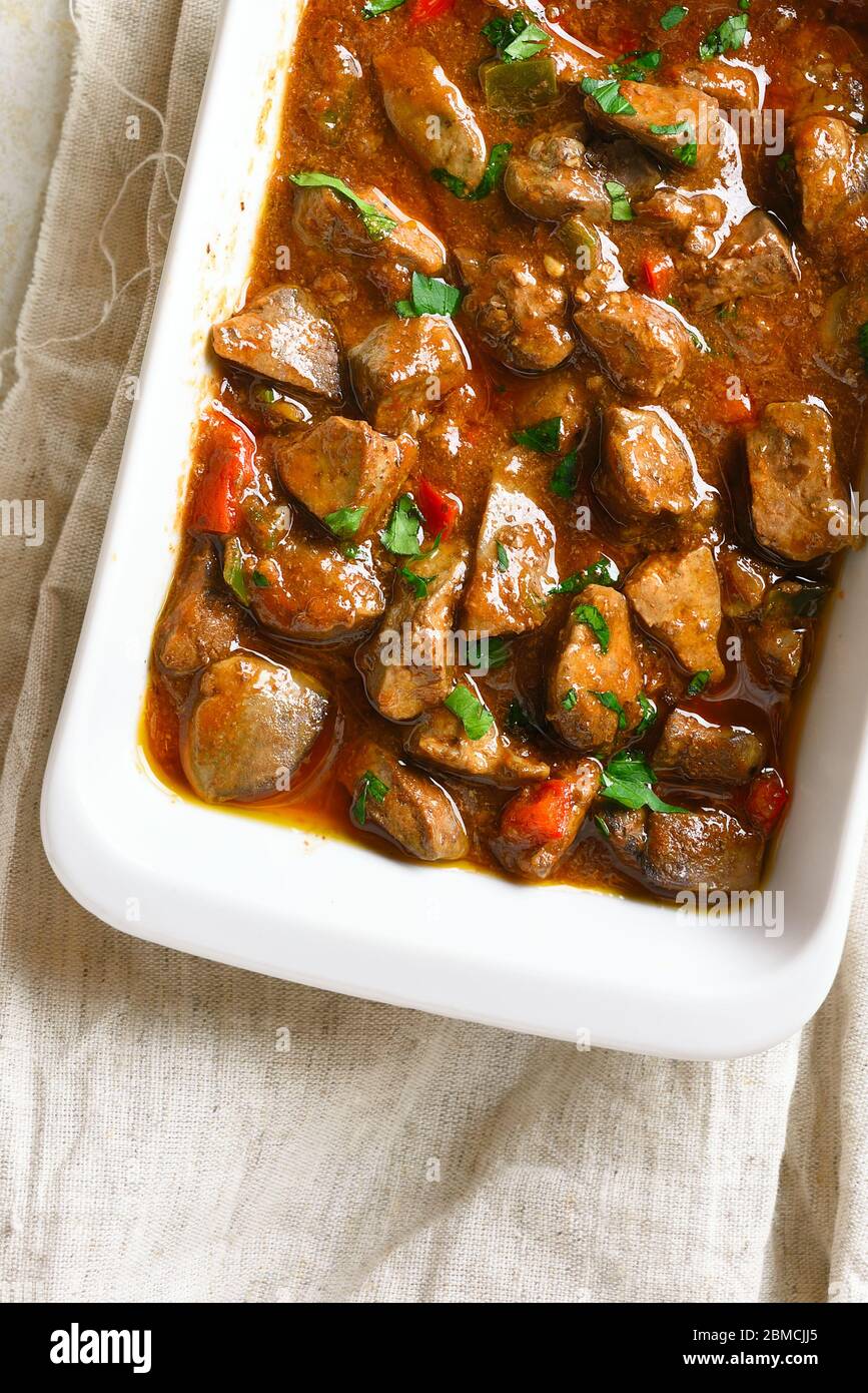 Close up of peri-peri chicken livers in baking dish over light ...