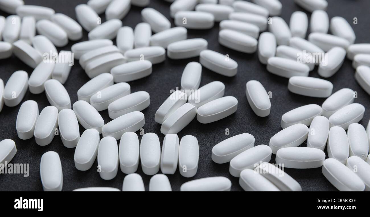 White tablets pills pattern over dark background Stock Photo - Alamy