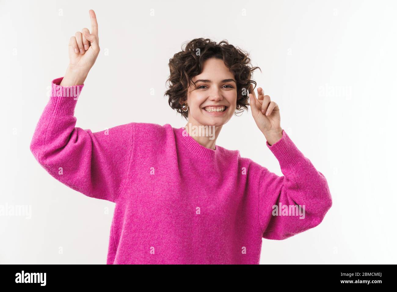Image of happy beautiful woman pointing finger upward and dancing ...