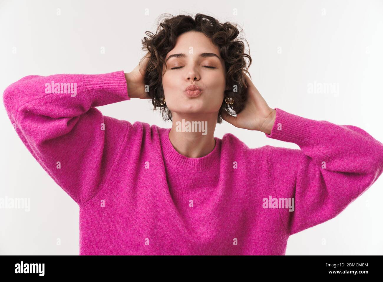 Image of happy caucasian woman making kiss lips and grabbing her head ...