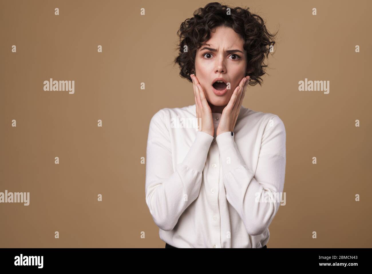 Image of curly beautiful woman expressing shock at camera isolated over ...