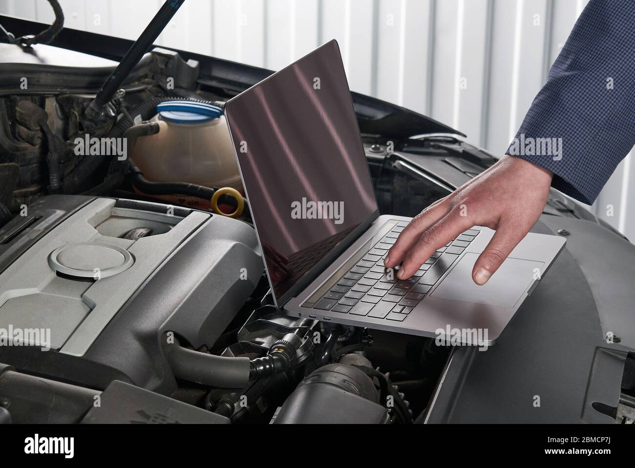 Car mechanic using computer in auto repair shop Stock Photo - Alamy