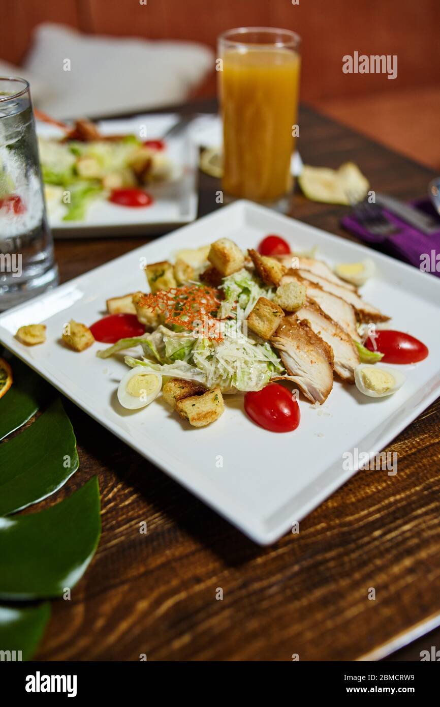 Caesar salad presentation commercial photo. Wooden table setting in ...