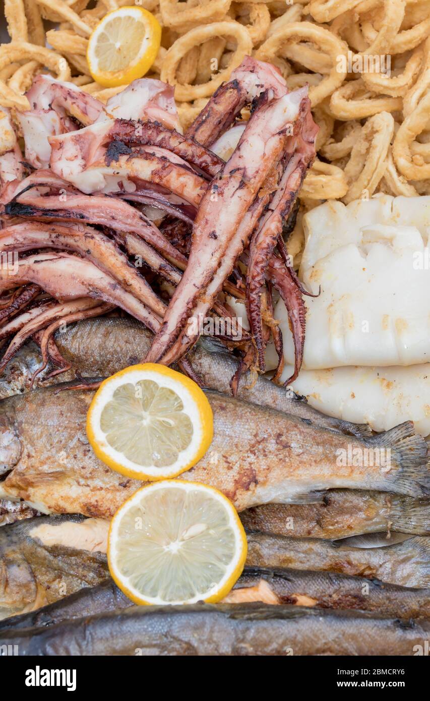 Fresh grilled seafood small baby octopus tentacles during hotel brunch ...