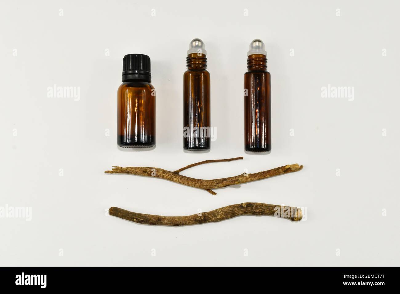 Three essential oil bottles with two tree branches Stock Photo - Alamy