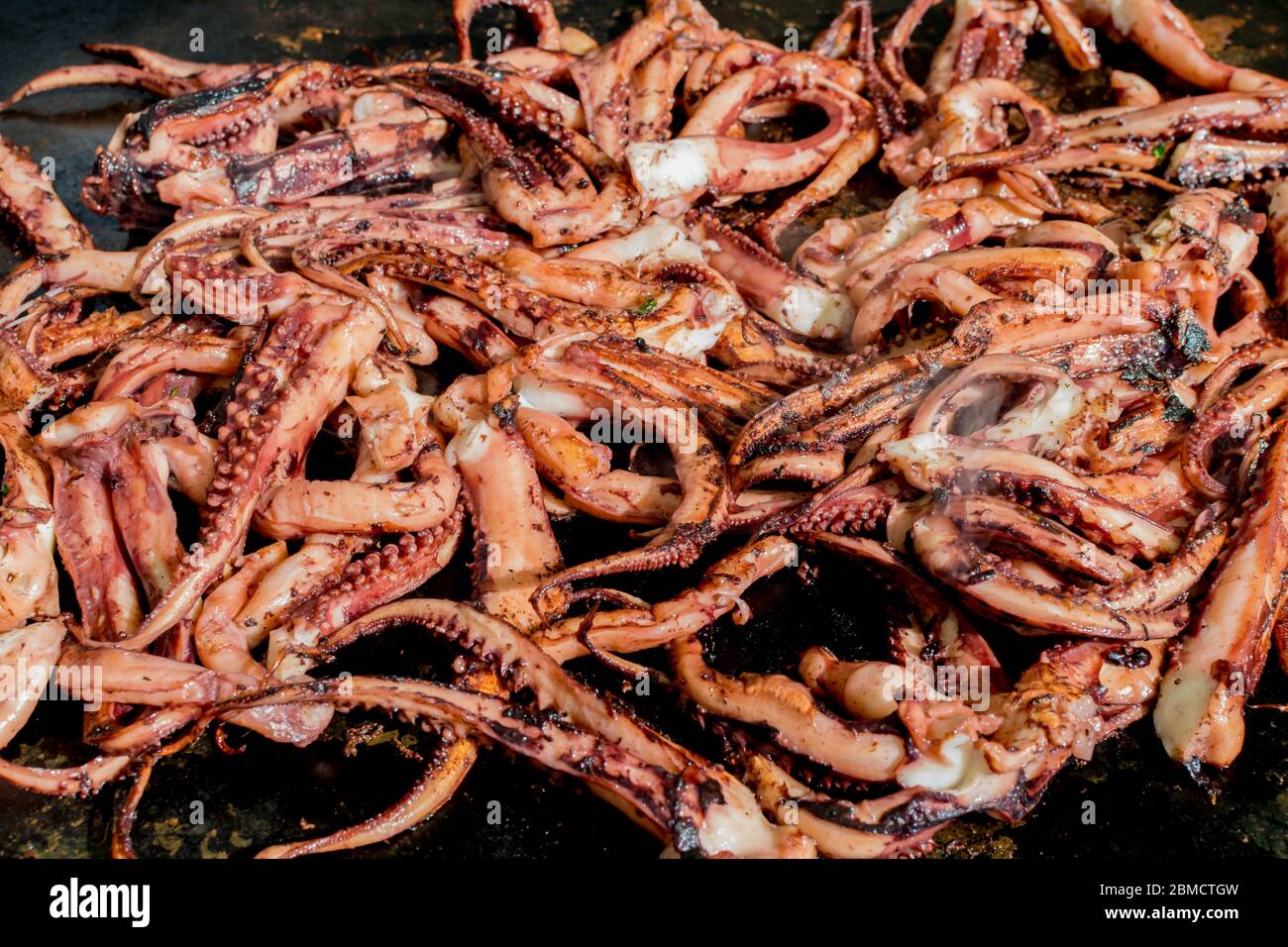 Fresh grilled seafood small baby octopus tentacles during hotel brunch ...