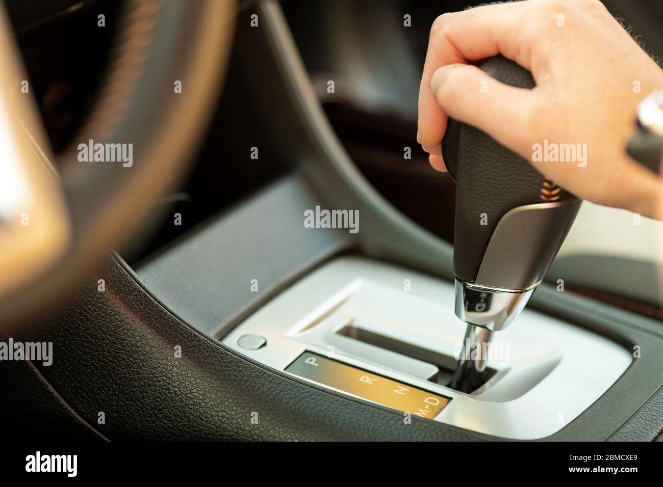 Close up of woman driver holding her hand on automatic gear shift stick ...