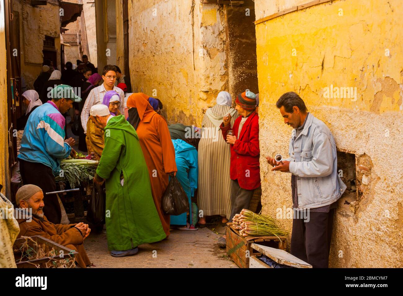 A street scene with people shopping in a small alley in the souk of the ...