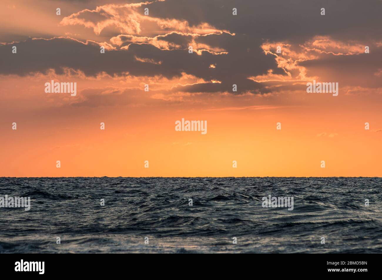 Golden hour of sunset at red sea shore with dramatic sky and the golden ...