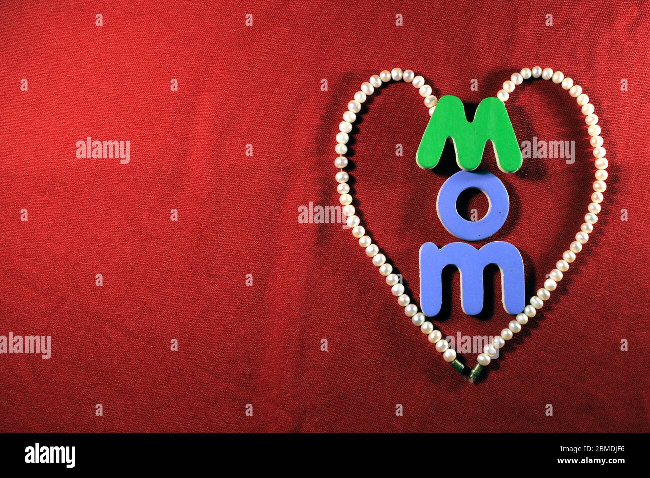 Colorful letters with mom isolated on red cloth background. I love mom ...