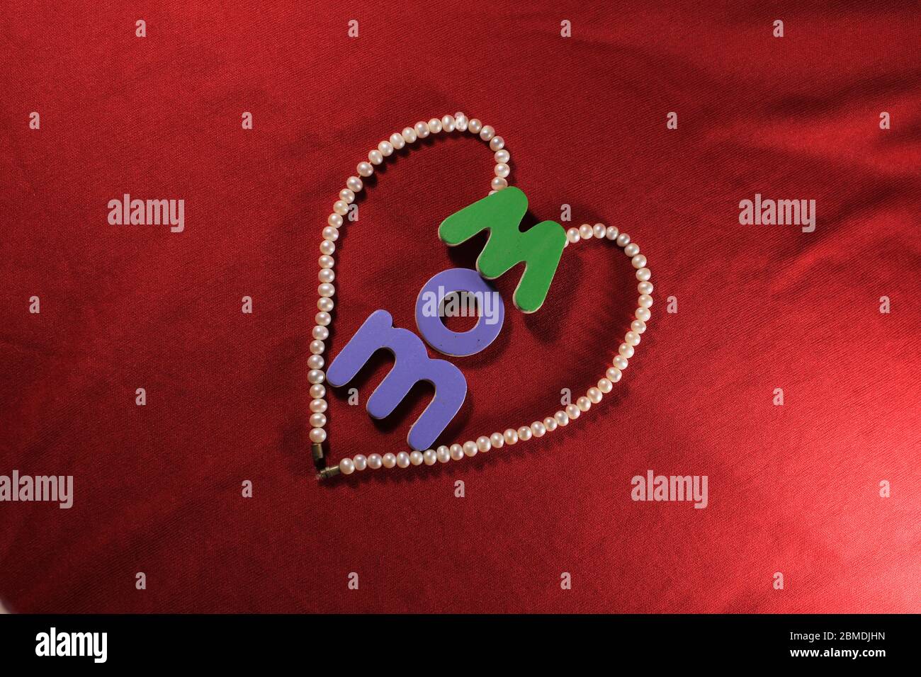 Colorful letters with mom isolated on red cloth background. I love mom ...