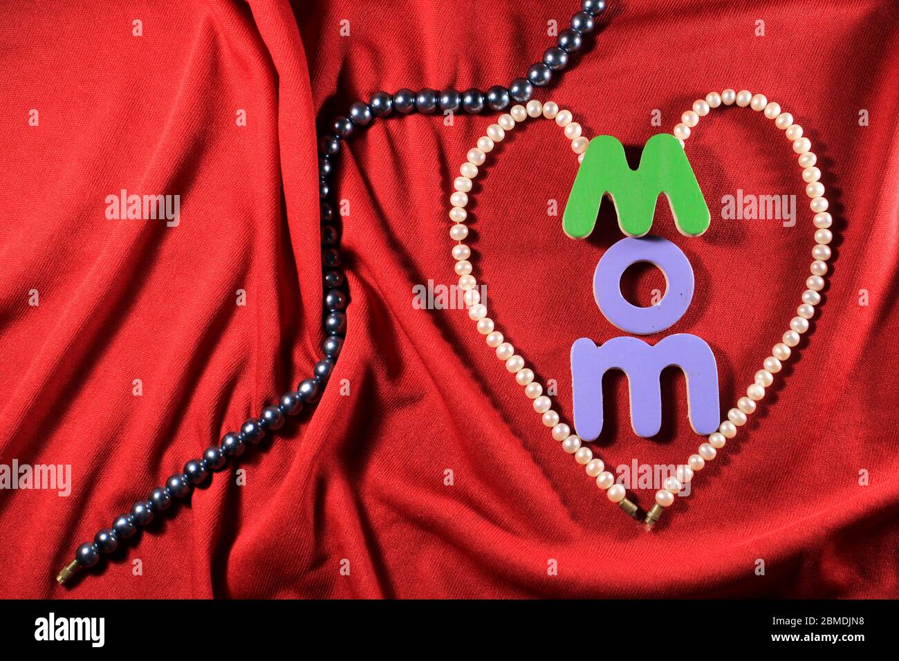 Colorful letters with mom isolated on red cloth background. I love mom ...