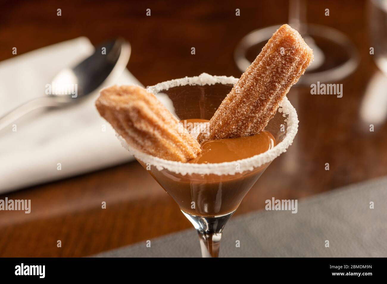 Mini churros with dulce de leche dessert on a glass on a blurred ...