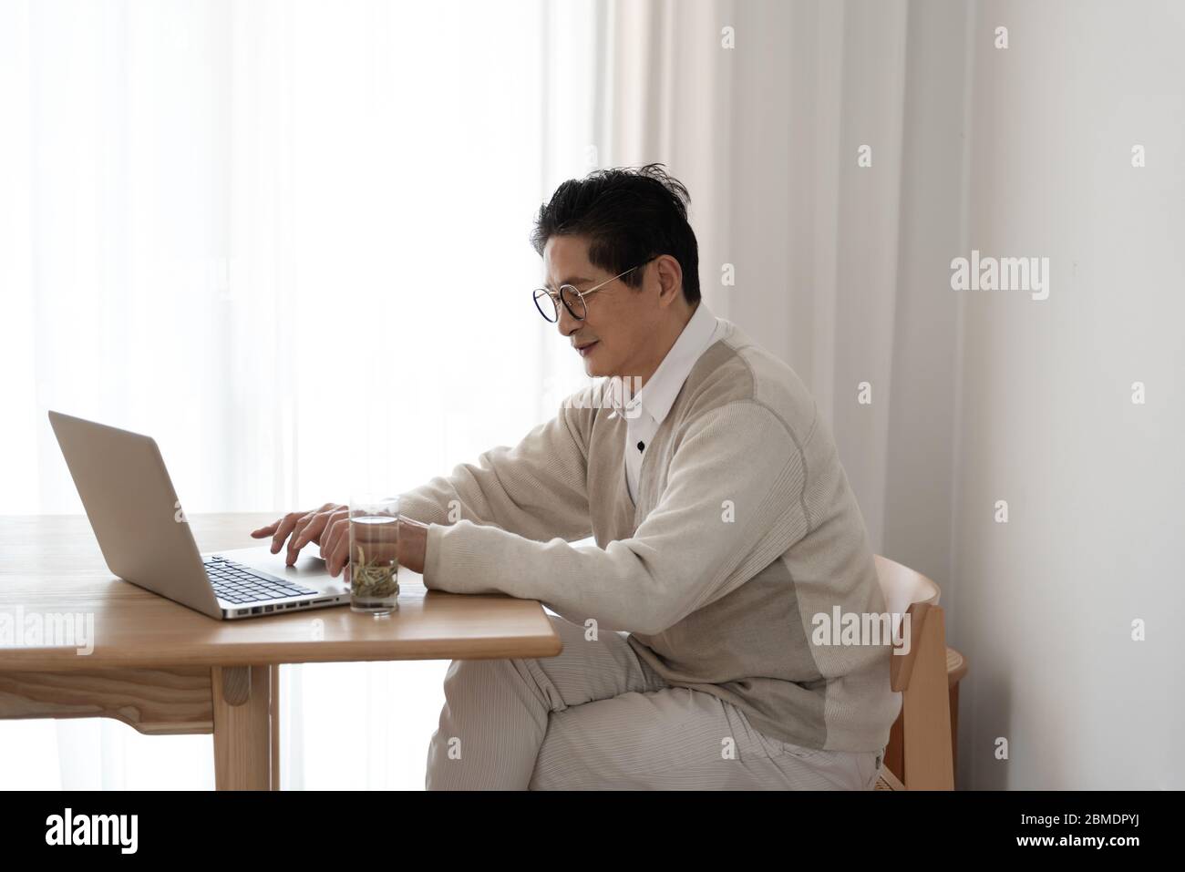 Asian seniors using computers at the desk Stock Photo - Alamy