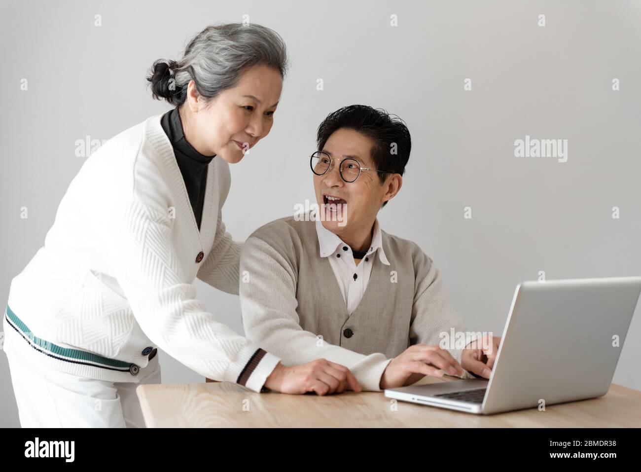 Asian seniors using computers at the desk Stock Photo - Alamy
