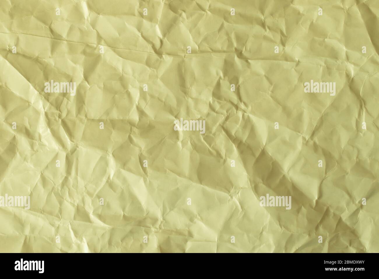 texture of a crumpled paper in light yellow color. Empty background ...