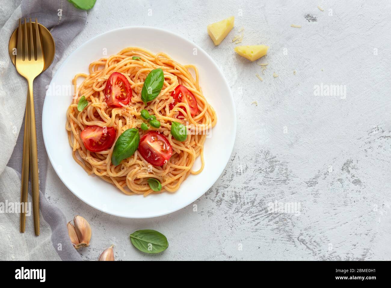 Pasta with cherry tomatoes, cheese and basil on a light background ...