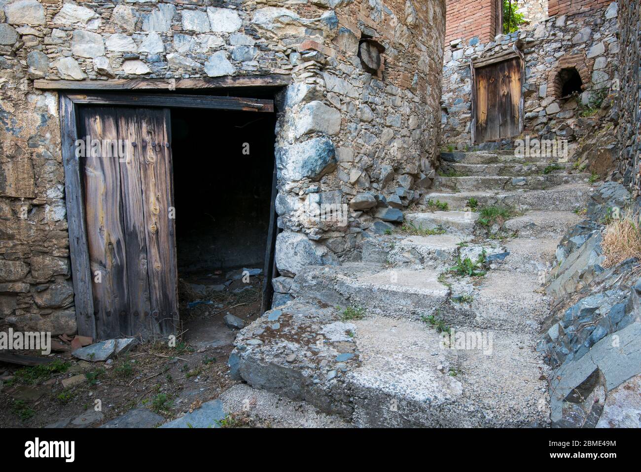Stoned step road leading to an open wooden vintage door at the ...