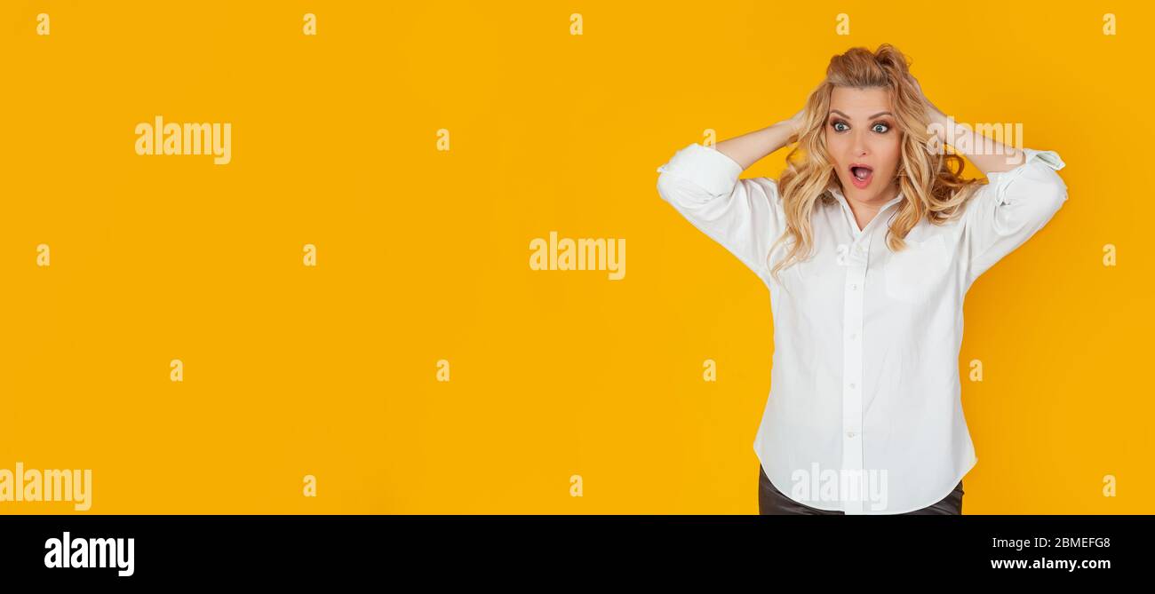 Portrait of a woman in a panic with her hands clutching her head ...