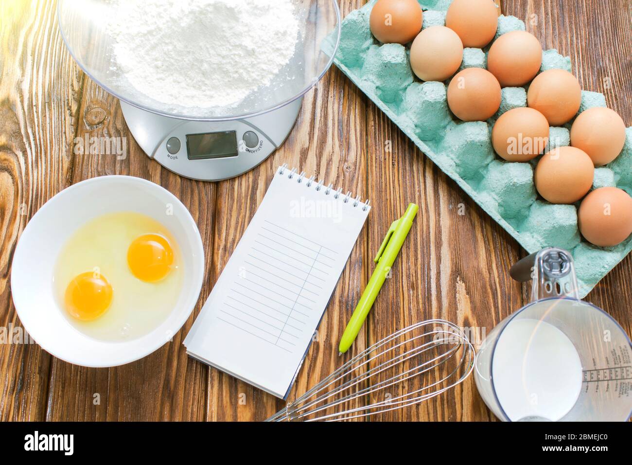 Ingredients for the dough. Flour, eggs, and blank notebook on black ...