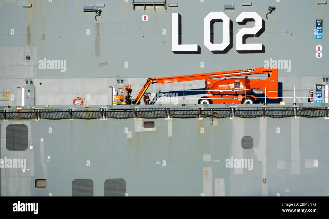 A red cherry picker high access lift on a warship in port Stock Photo ...