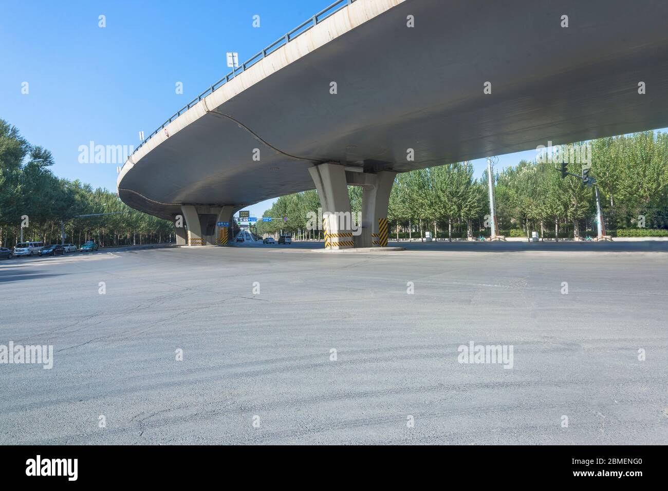 Under the overpass, car-free asphalt road, modern city building skyline ...