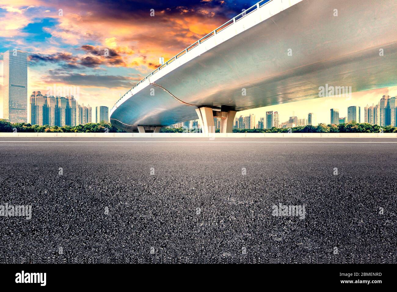 Under the overpass, car-free asphalt road, modern city building skyline ...