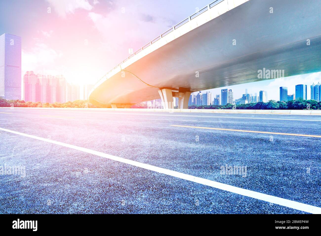 Under the overpass, car-free asphalt road, modern city building skyline ...