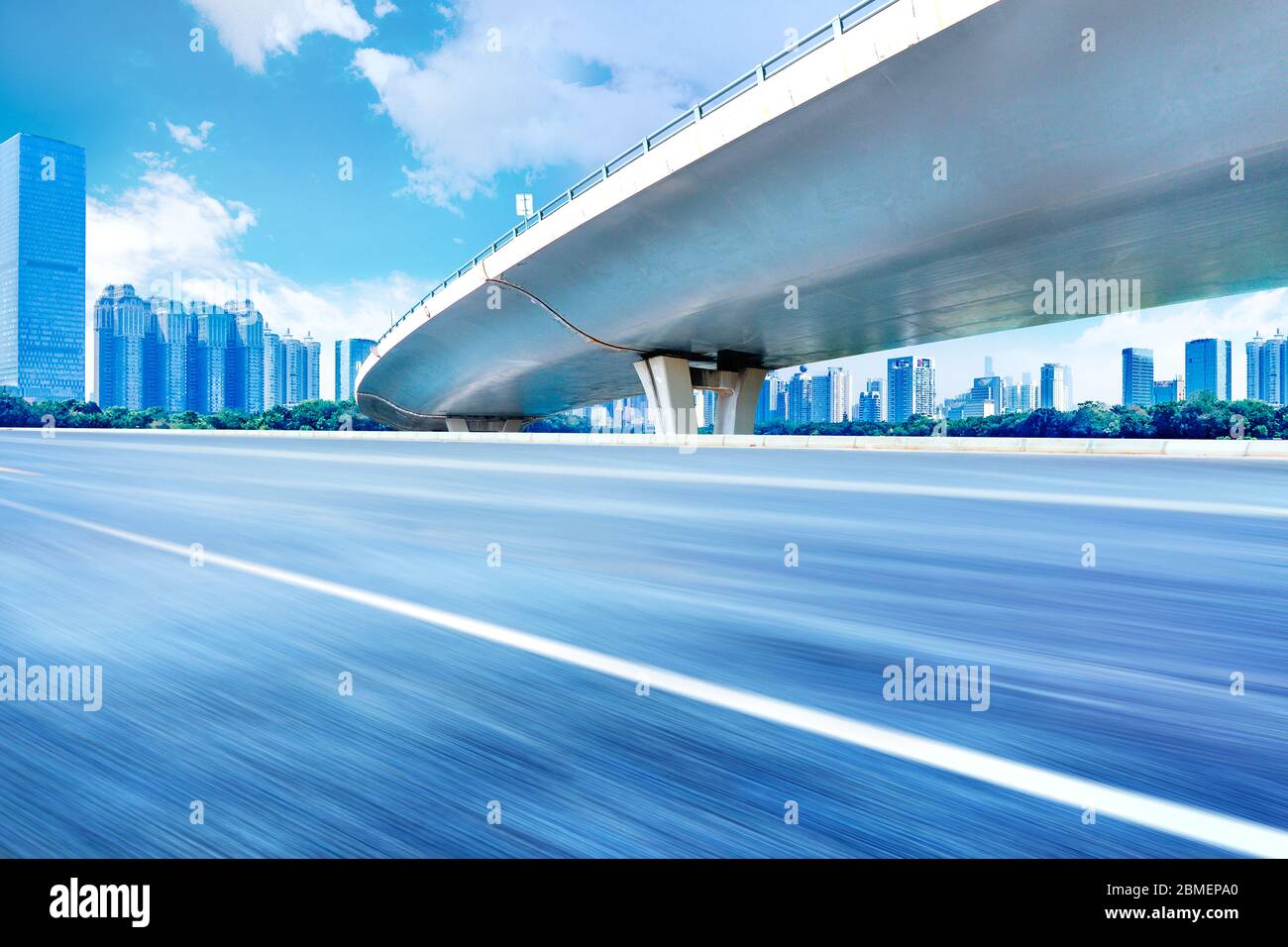 Under the overpass, car-free asphalt road, modern city building skyline ...
