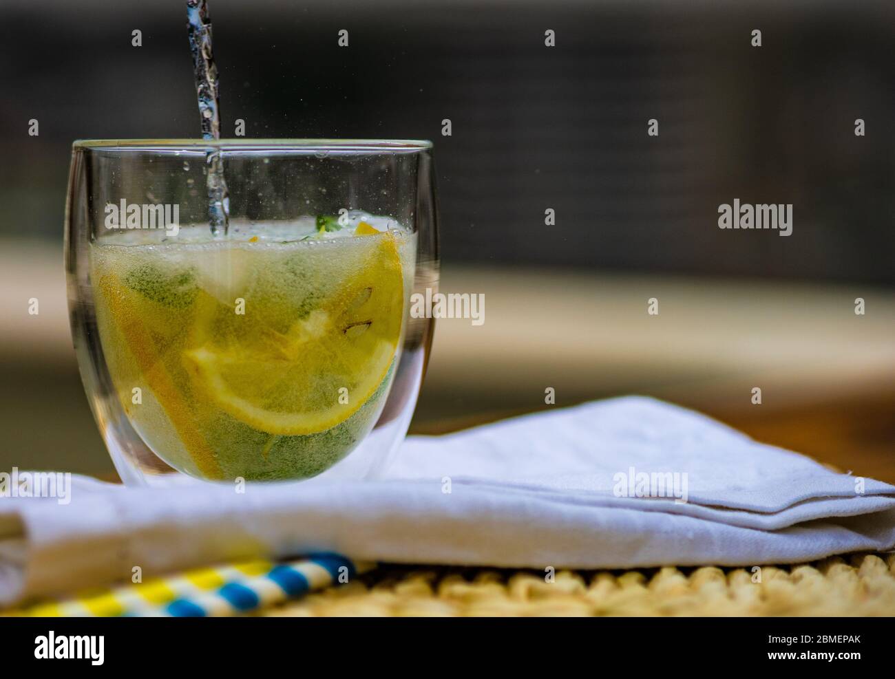 Tasty gin and tonic cocktail with slices of lemon and fresh mint on ...
